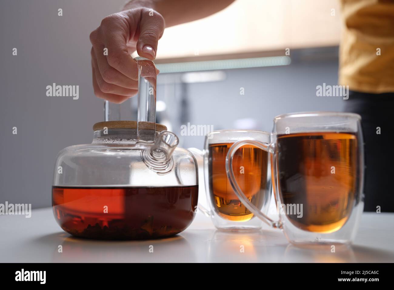 Black tea in a transparent teapot and cups closeup Stock Photo - Alamy