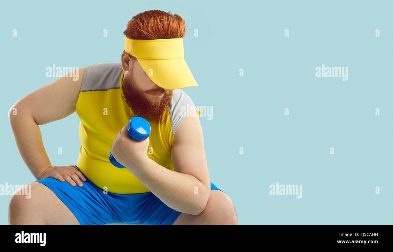 Serious fat young man is actively training with dumbbell isolated on ...