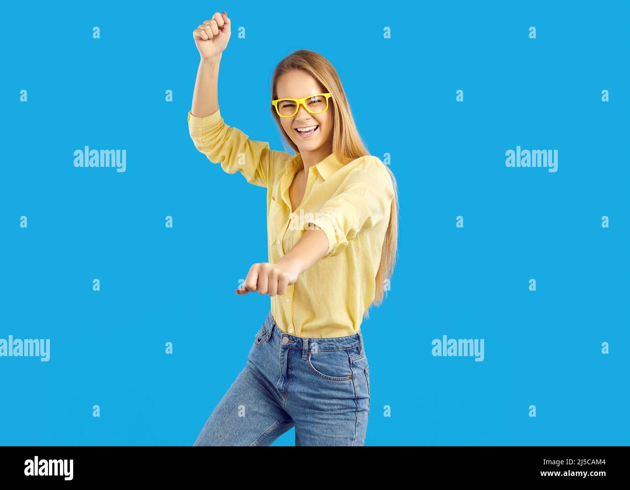 Smiling young woman dancing on studio background Stock Photo - Alamy