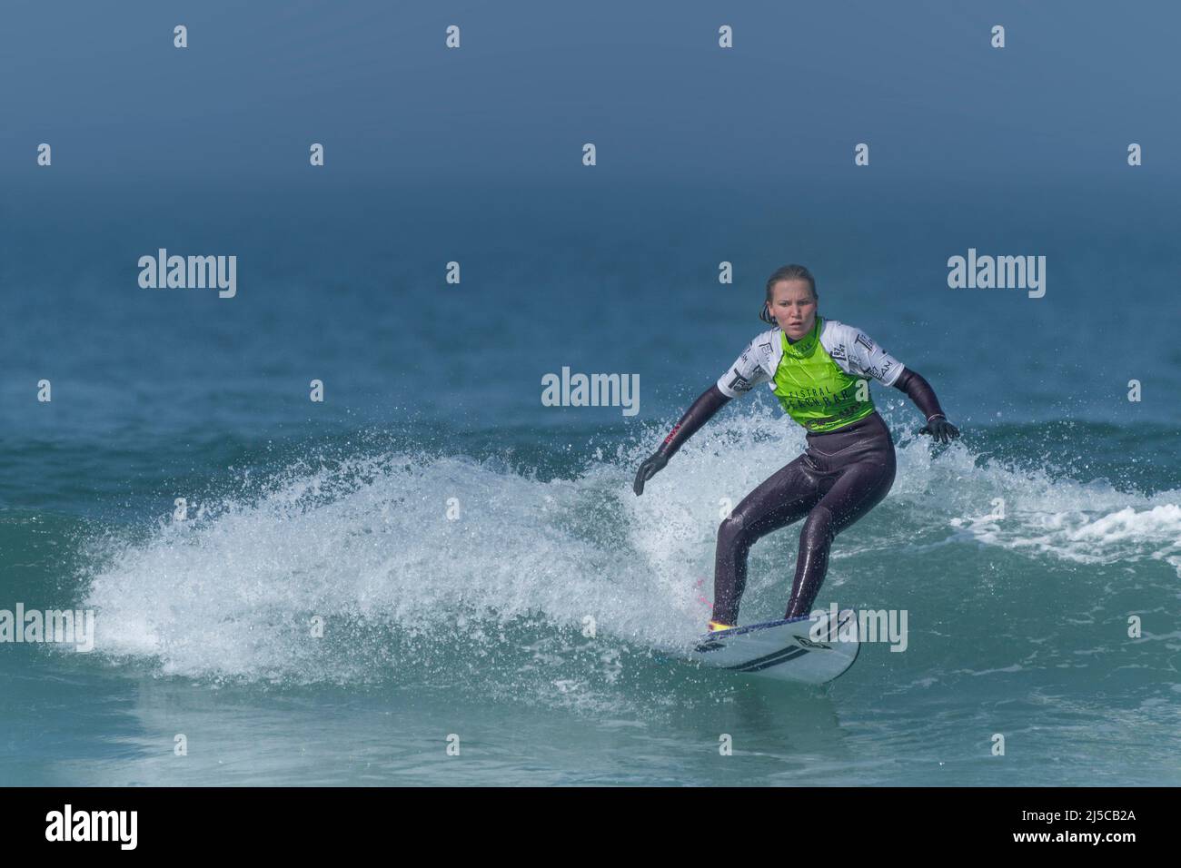 A female surfer competing in a surfing competition at Fistral in ...