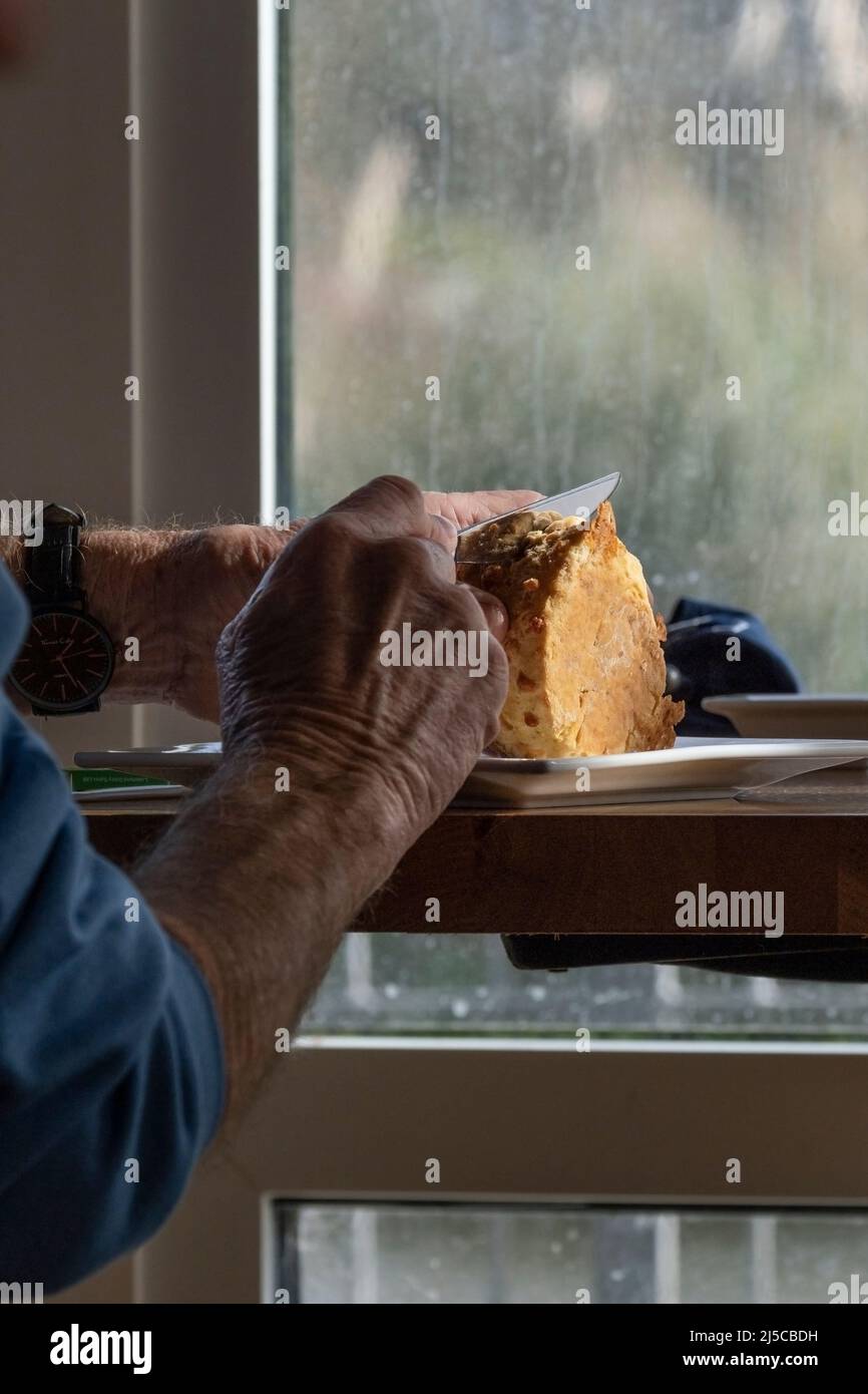 A customer cutting a scone with a knife inside a restaurant Stock Photo ...
