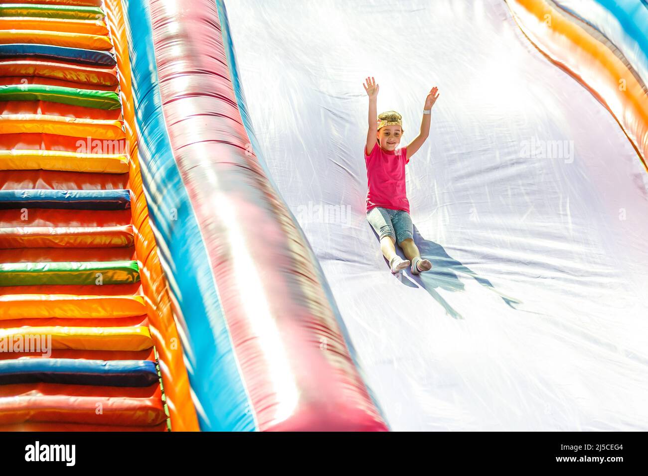 Little Girl sliding down an inflatable Slide Stock Photo - Alamy