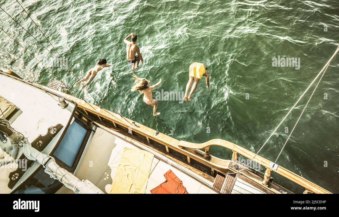 Aerial view of young people jumping from sailing boat on sea trip ...