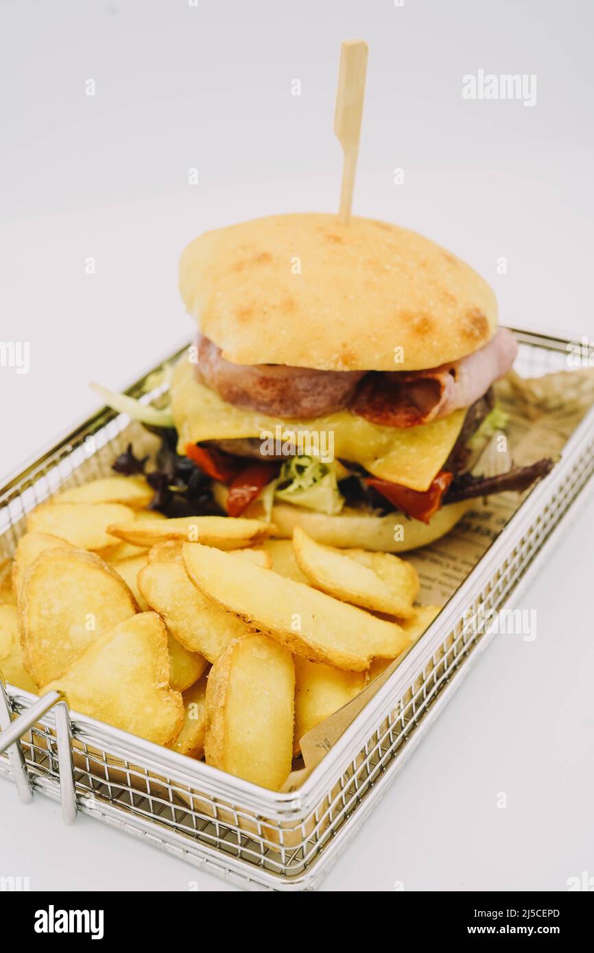 Cheeseburger, ham, lettuce and tomato, accompanied by French fries ...