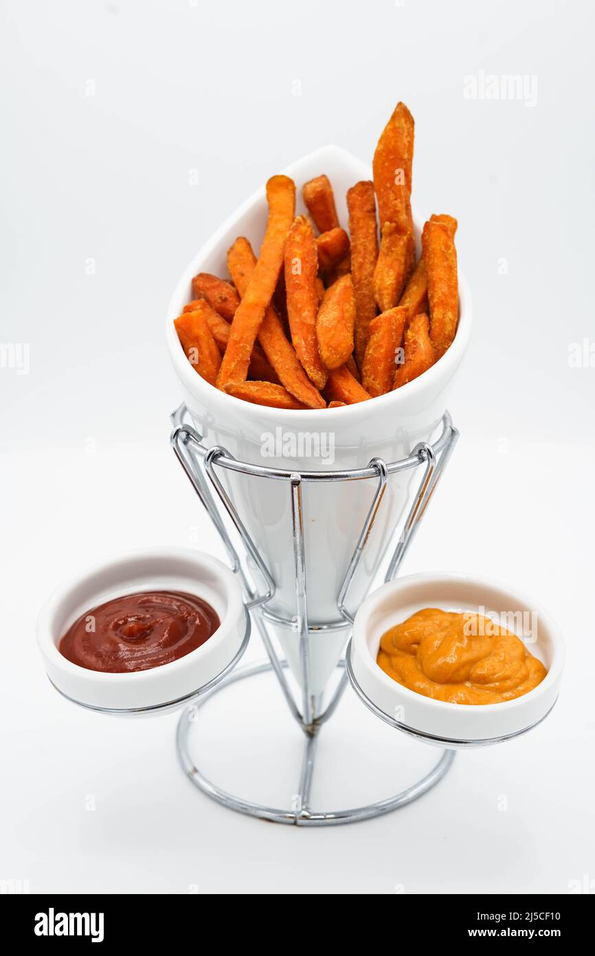 Cone with sweet potatoes and chips to eat and dip in sauce Stock Photo ...