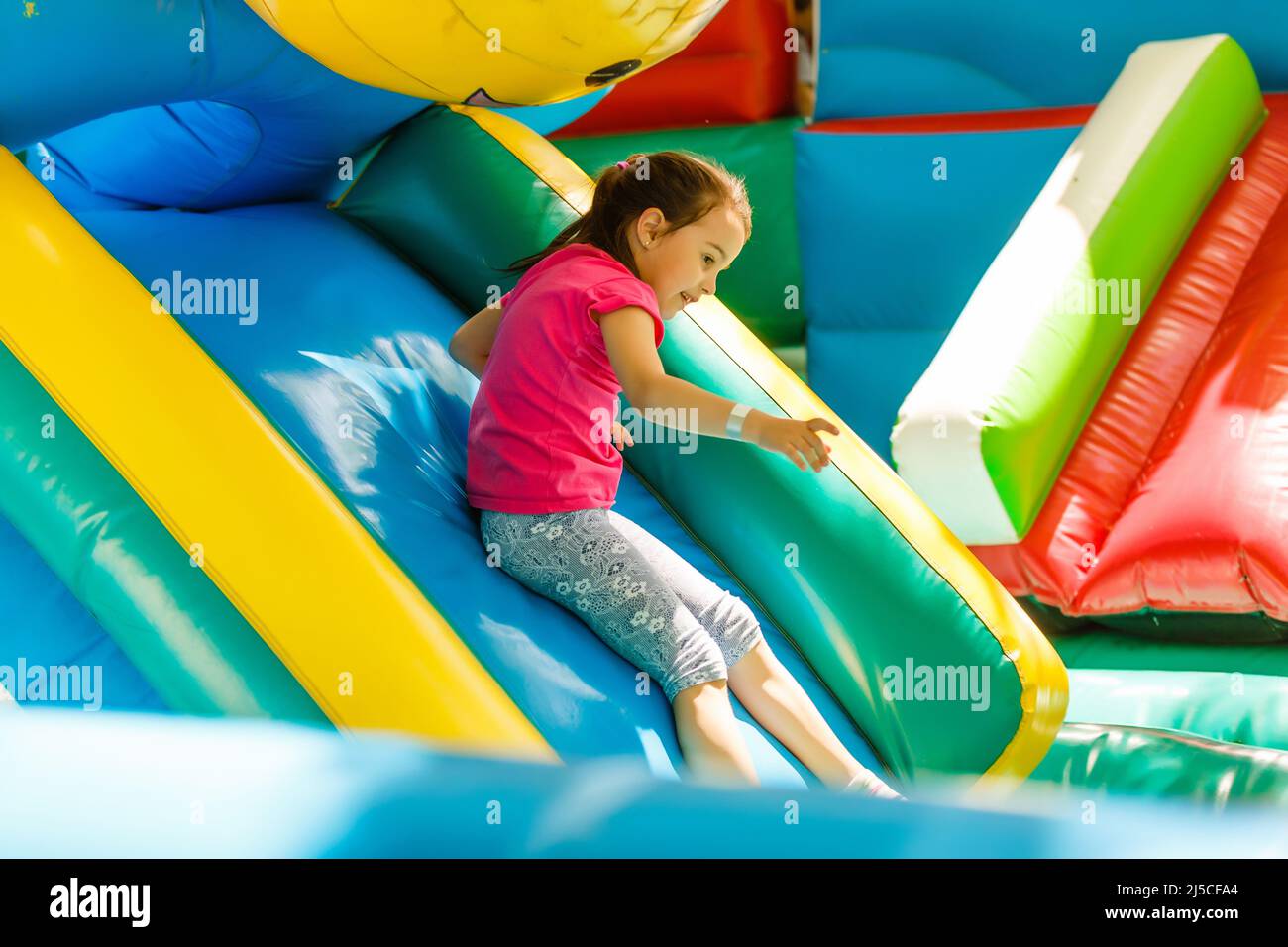Little Girl sliding down an inflatable Slide Stock Photo - Alamy
