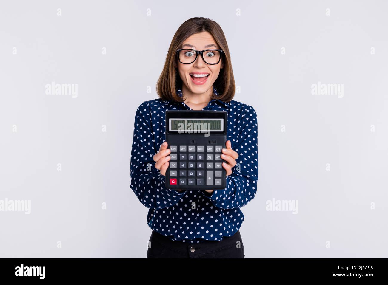 Portrait of attractive cheerful girl showing number calculator amount ...