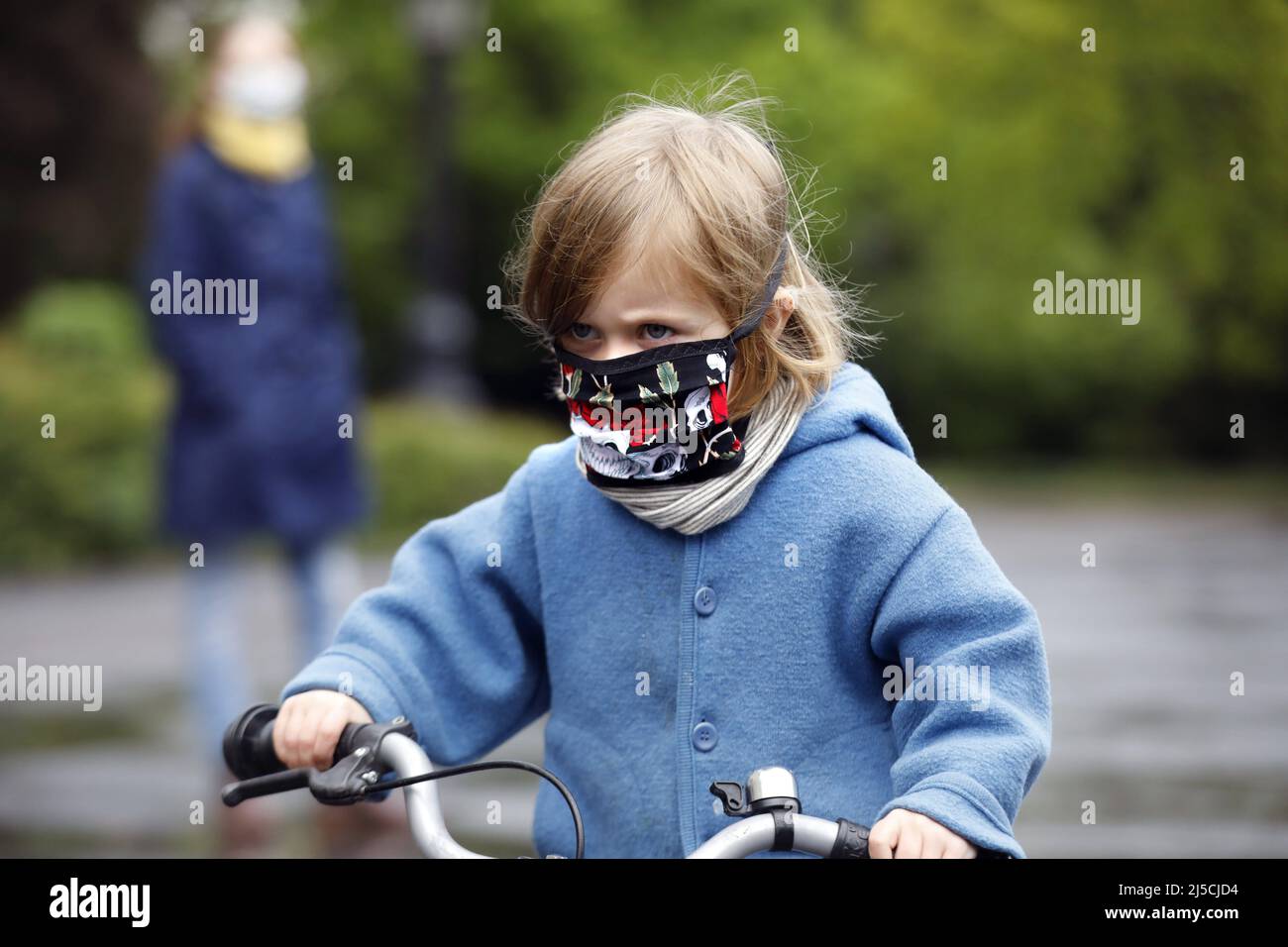 Finally getting out - family wearing face masks in a public park while ...