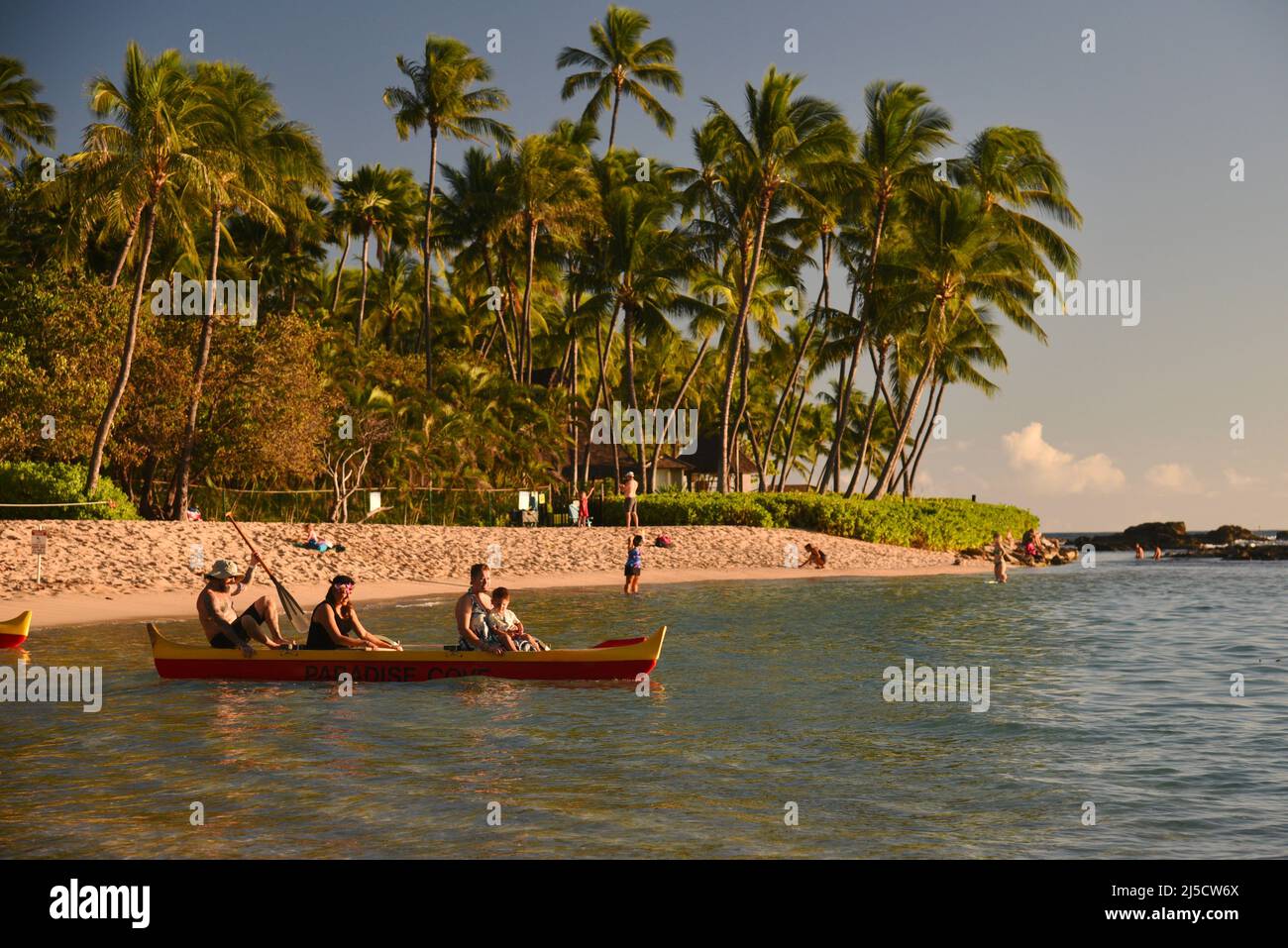 Guests paddling to going on Hawaiian outrigger canoe sunset ride as a ...