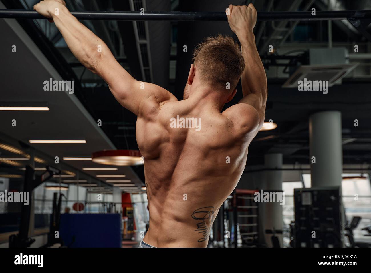 Muscular strong man exercising in the sport gym, Man doing horizontal ...