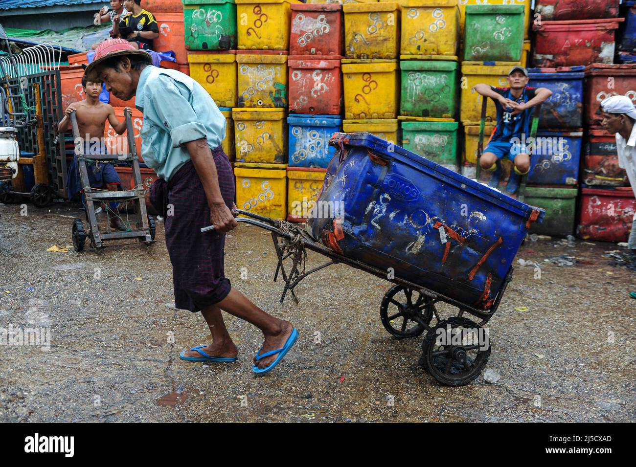28.06.2014, Yangon, Myanmar, Asia - A worker pulls a sack truck with a ...