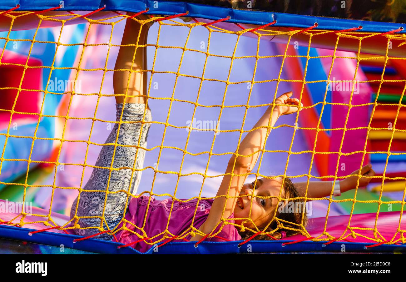 Little child jumping at trampoline in indoors playground. Active ...
