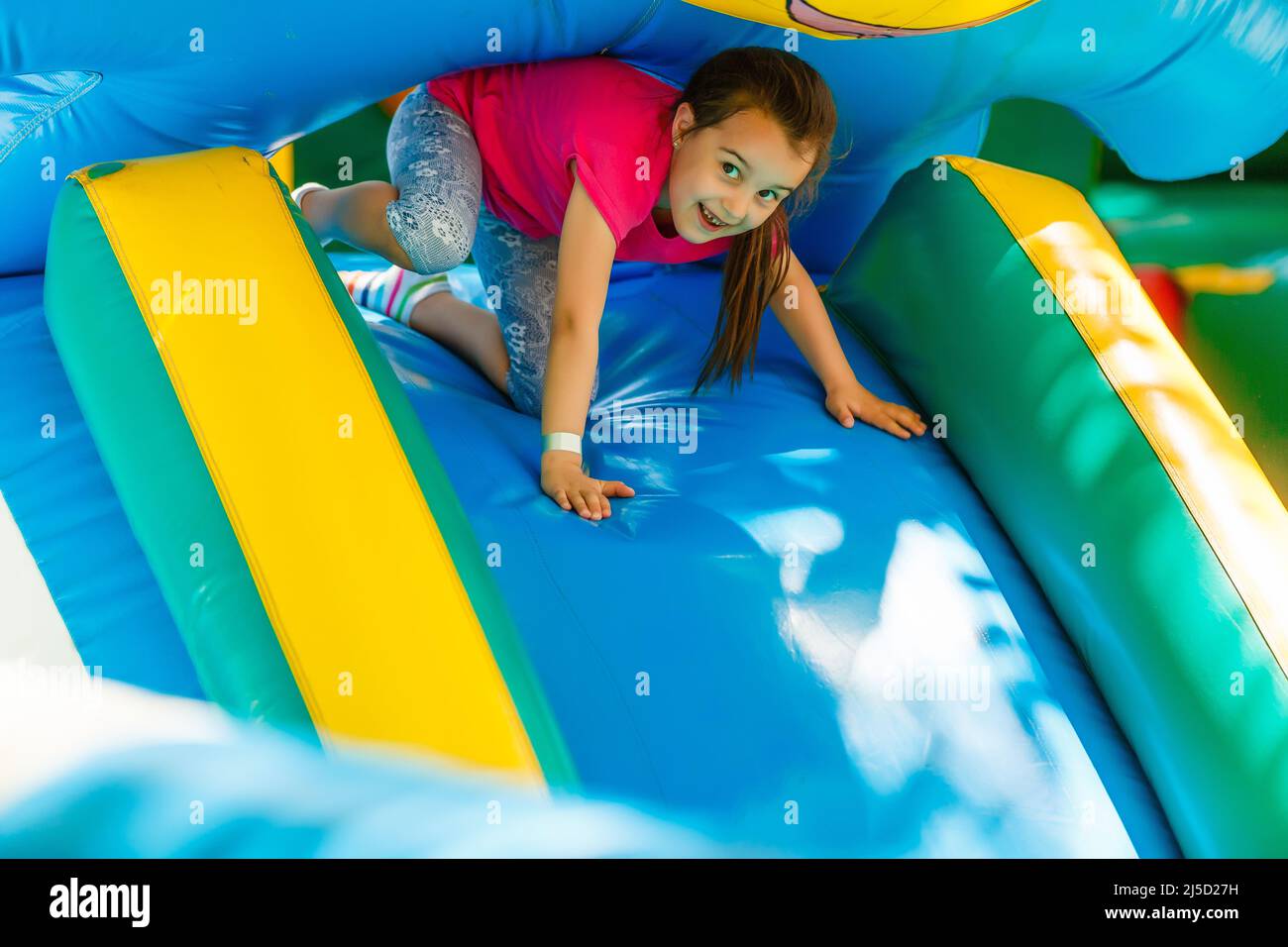 Little Girl sliding down an inflatable Slide Stock Photo - Alamy