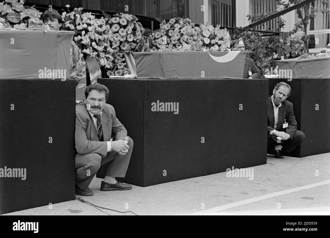 Cologne, June 3, 1993 - Turkish men sit next to the coffins at a ...