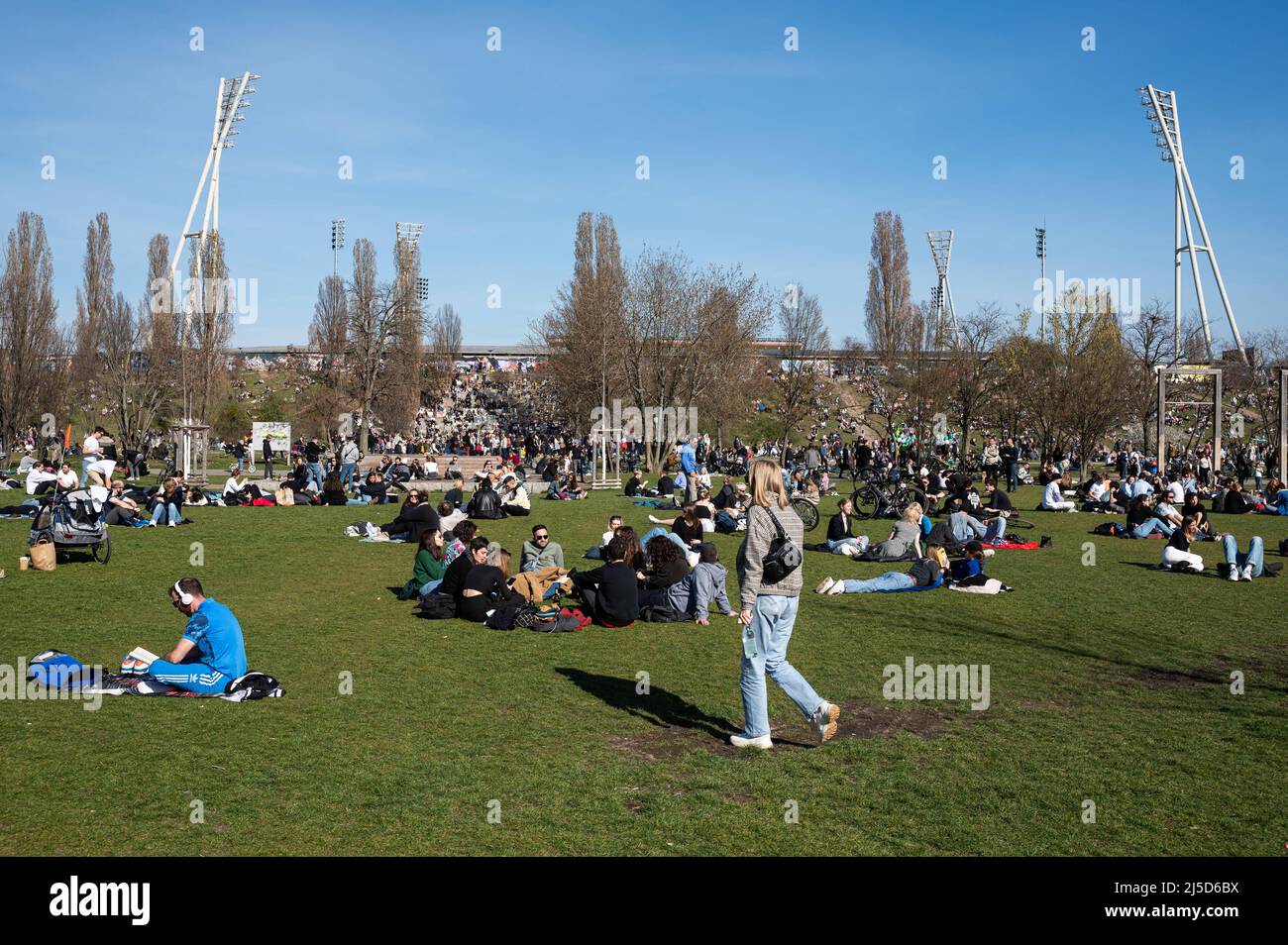 27.03.2022, Berlin, Germany, Europe - People are lying in the grass and ...