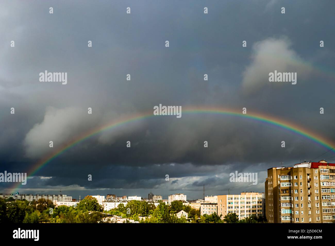 Rainbow over city. Atmospheric phenomenon in sky against background of ...