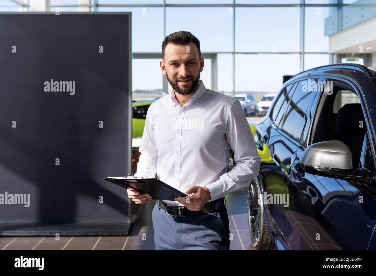 presentable car dealership manager next to a luxury SUV Stock Photo - Alamy