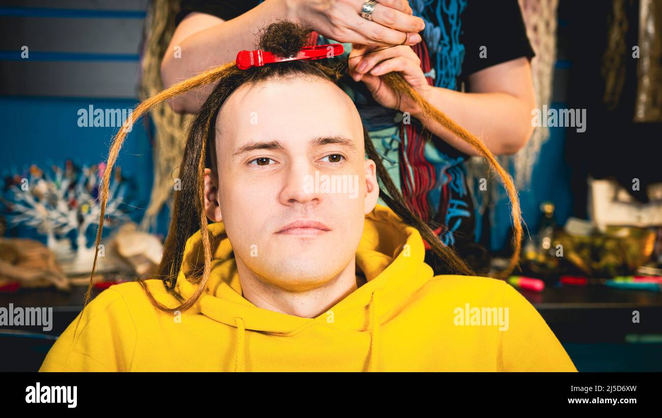 Professional hairstylist makes brown dreadlocks for client Stock Photo ...