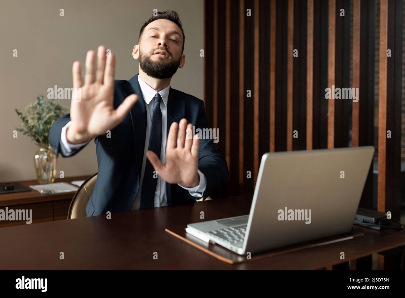 businessman with the palms of his hands demonstrates refusal while ...