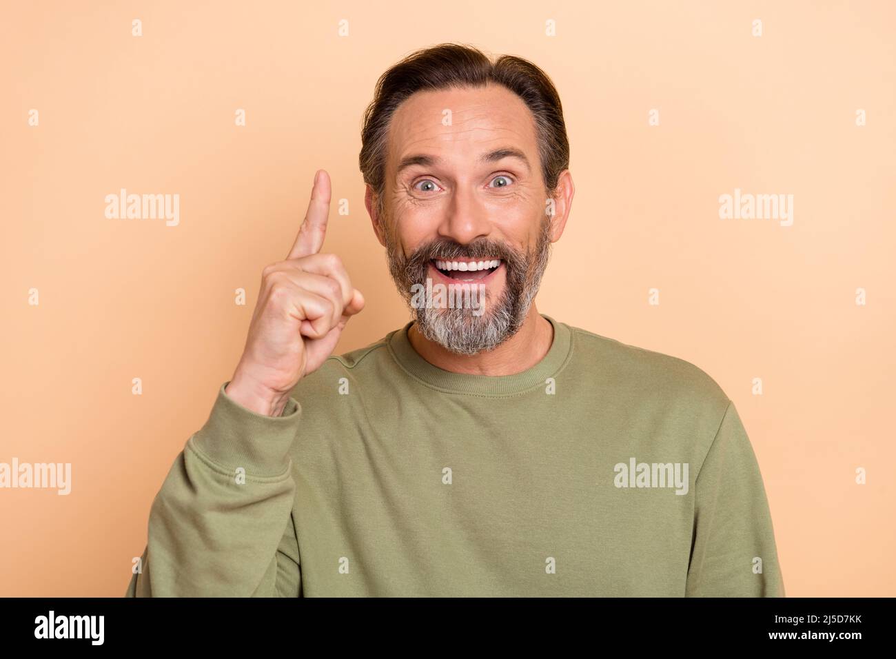 Portrait of attractive cheerful amazed man pointing forefinger up good ...