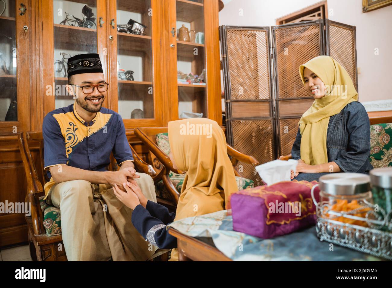 muslim family shake and kissing hand during idul fitri Stock Photo - Alamy