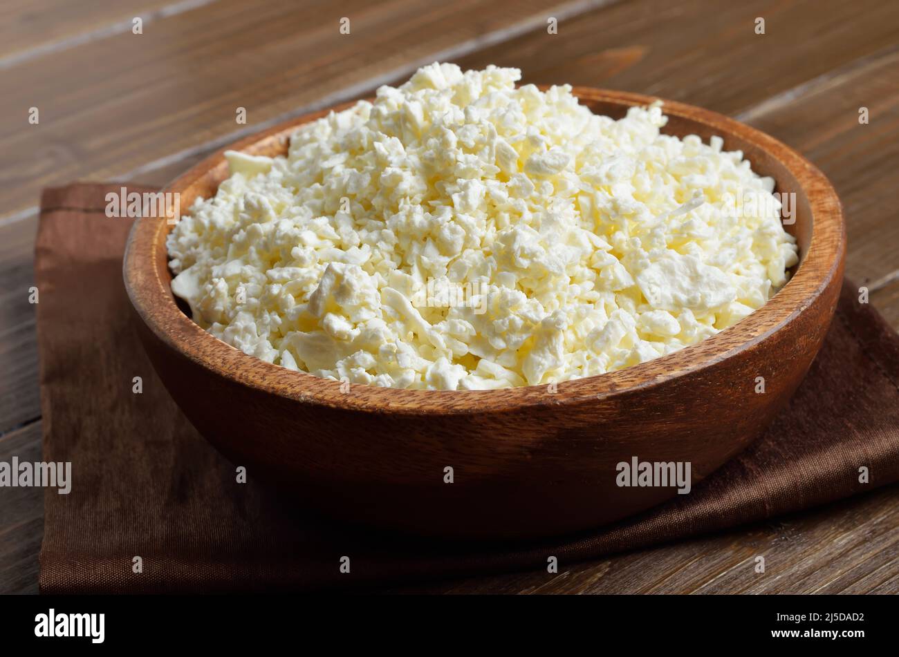 Homemade curd cheese in wooden bowl on table, close up view Stock Photo ...