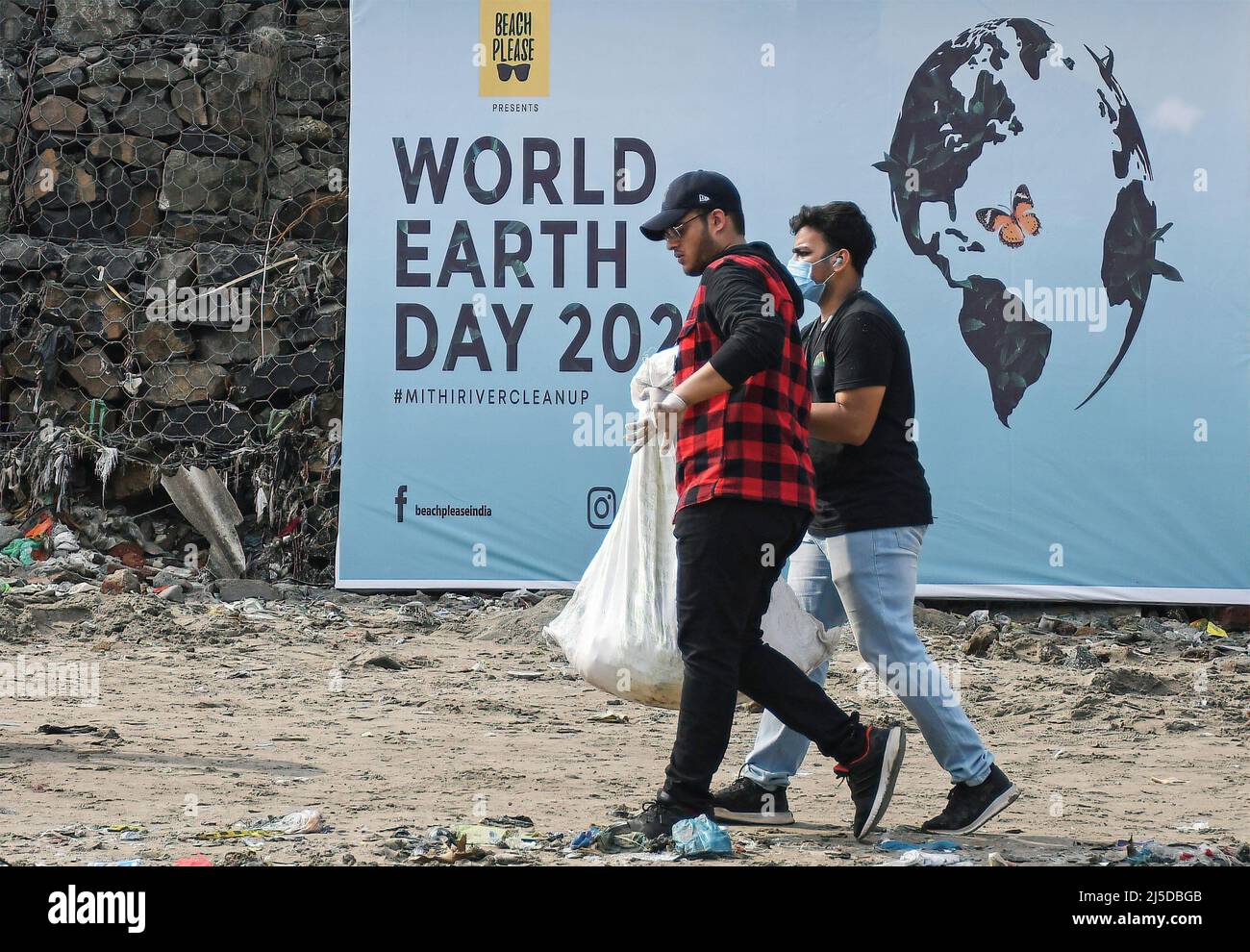 Mumbai, India. 22nd Apr, 2022. Volunteers carry garbage during a clean ...