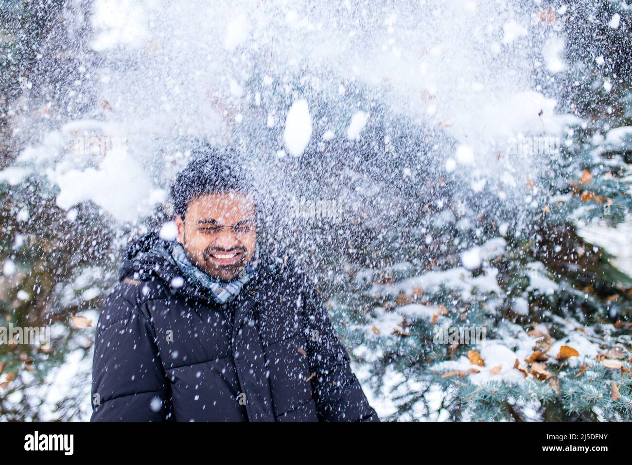 indian man enjoying snowflakes falling from upwards in forest Stock ...