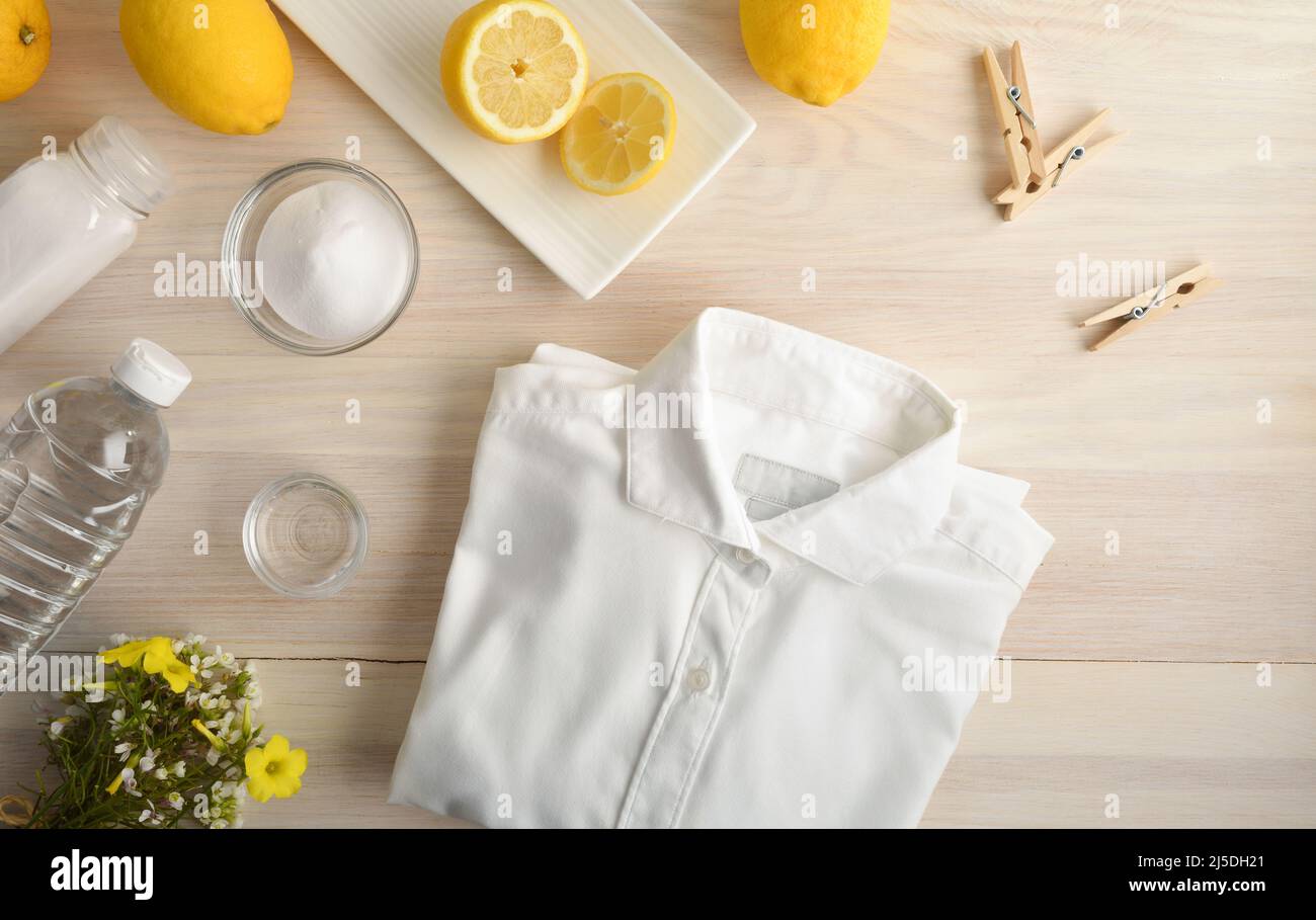 Alternative clothes cleaning products on wooden table with clothes and ...