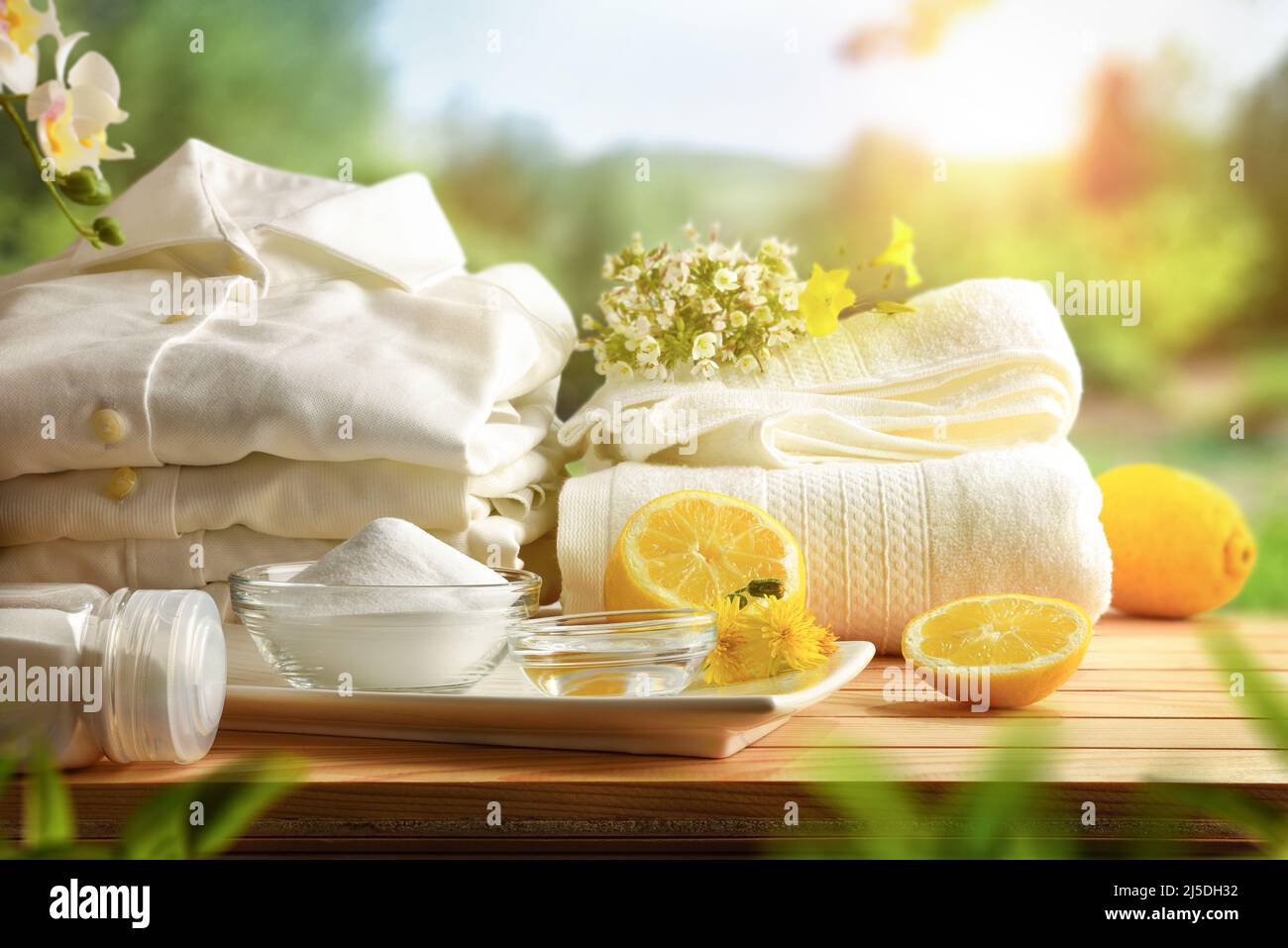 Clean folded clothes with organic and homemade products on wooden table ...