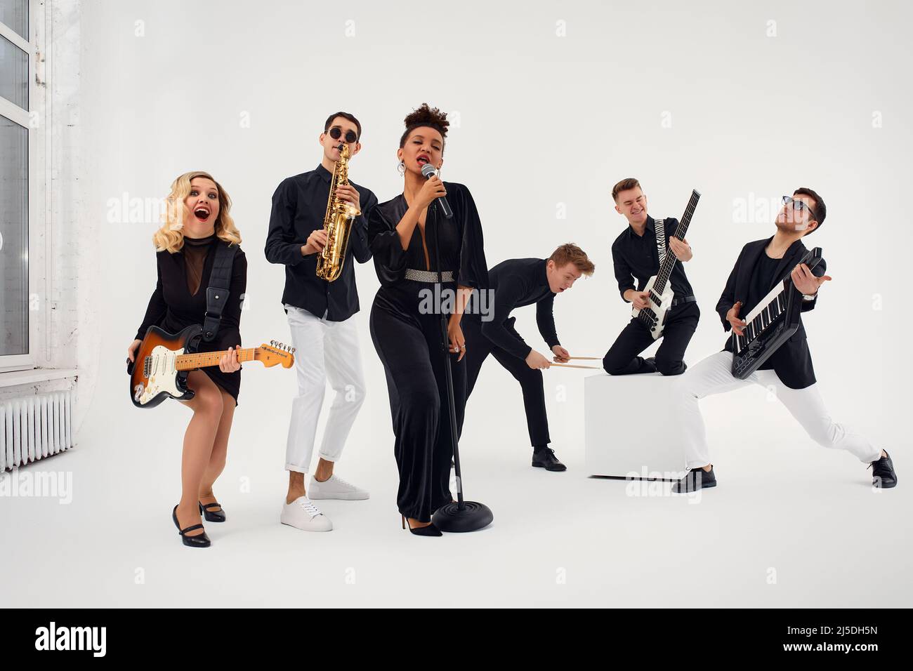 Portrait of diverse group of young people musical band playing with ...