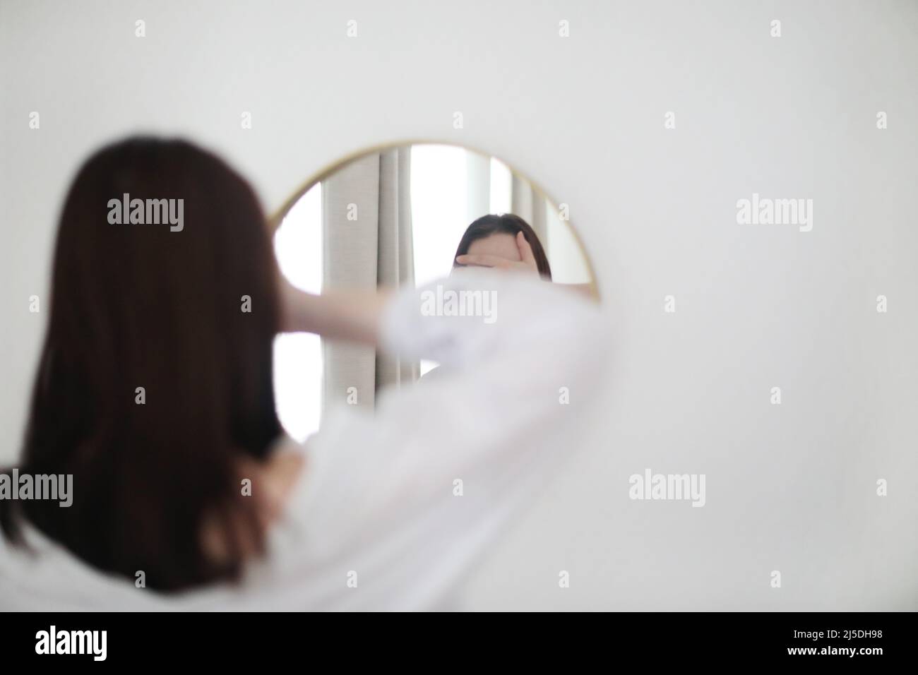 young woman looking in the mirror. Mental health problems in self ...