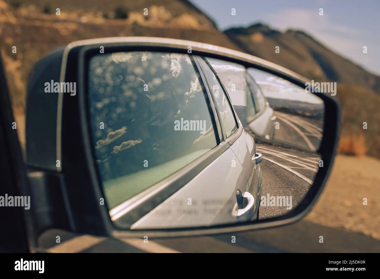 Side car mirror view close-up. Driving through the hills, road trip ...
