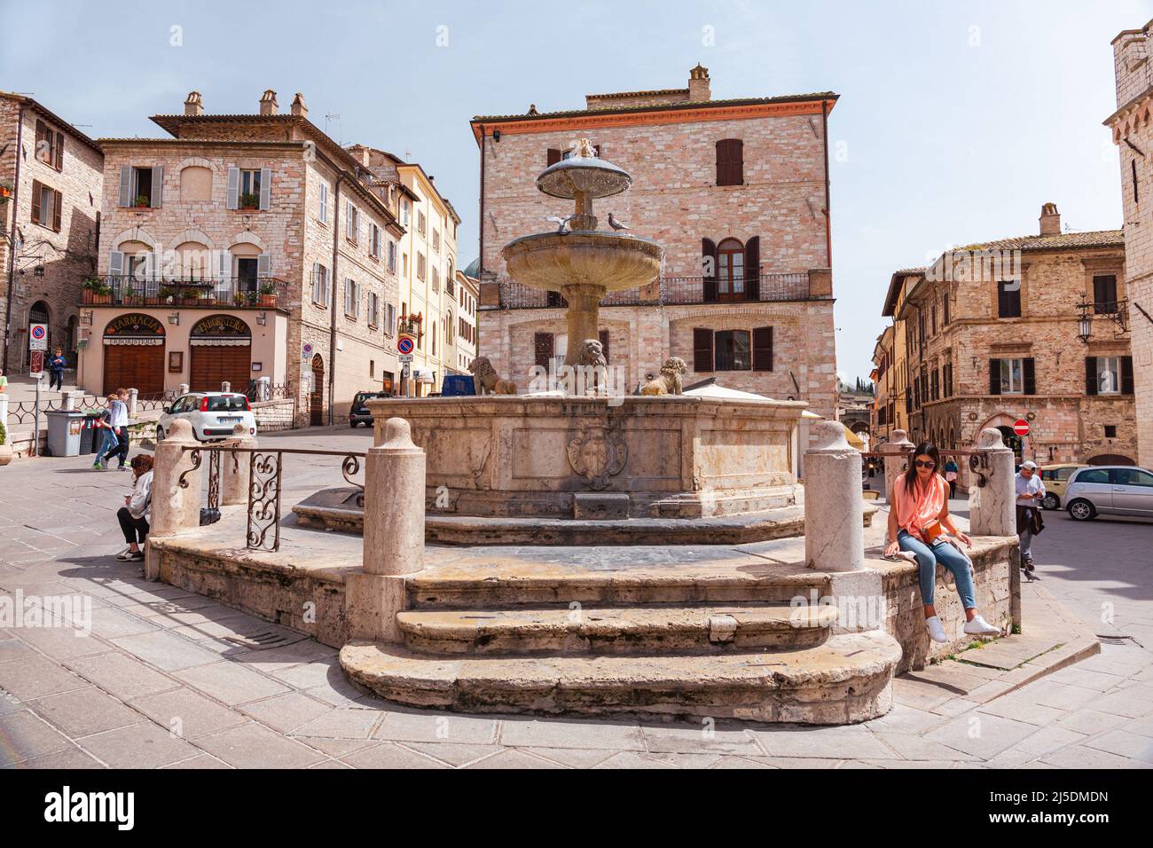 Ancient fountain and people in the Piazza del Comune of the small town ...