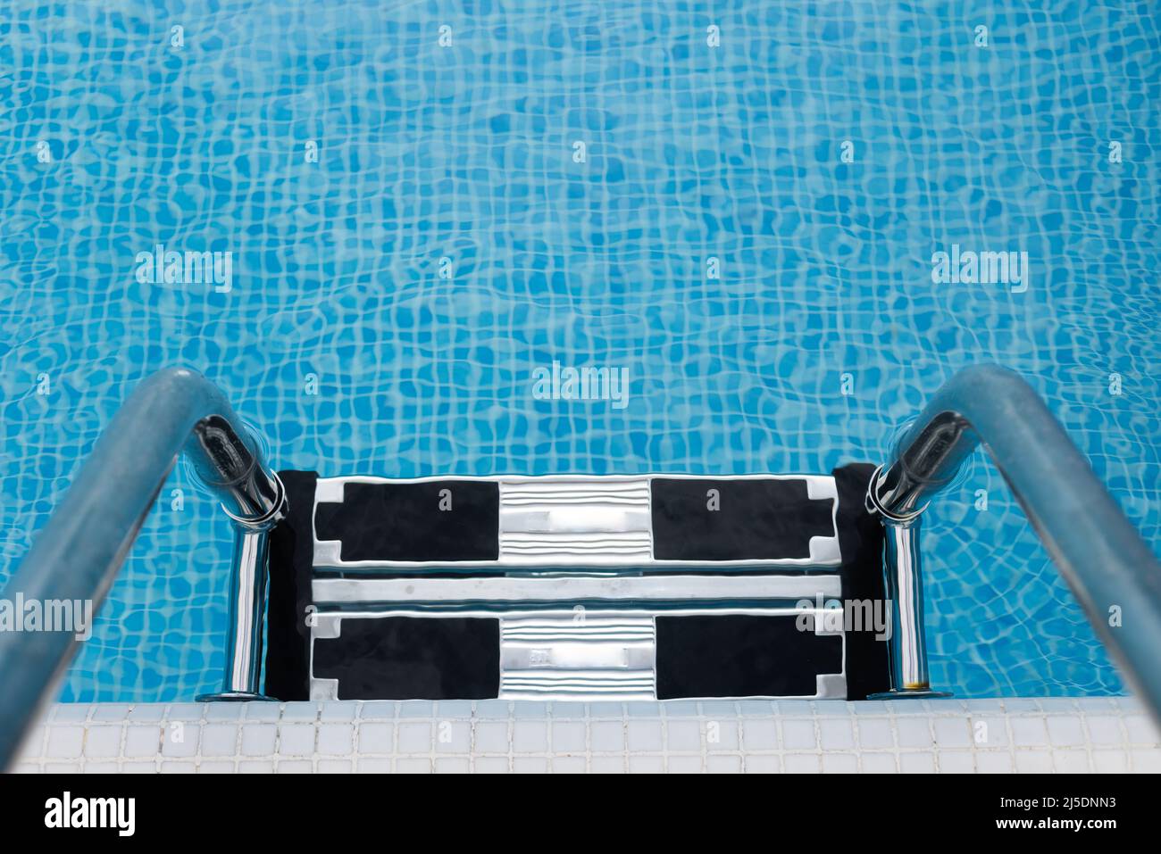 Steel railings stairs in a pool with a blue water Stock Photo - Alamy
