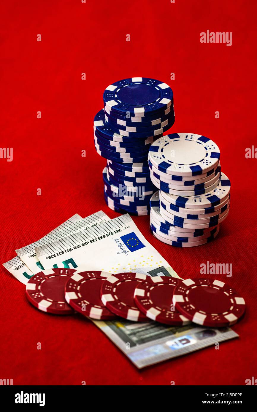 Stacks of poker chips with money on red background, EURO currency Stock ...
