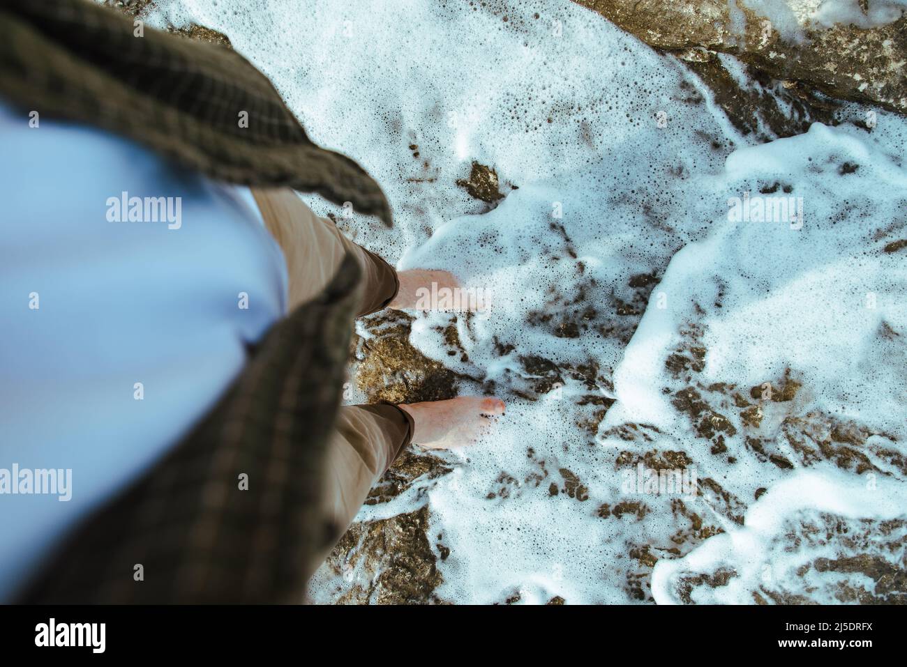 overhead view man barefoot walking by sea rocky beach. copy space Stock ...