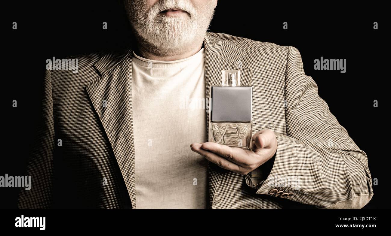Male holding up bottle of perfume. Aged man perfume, fragrance. Perfume ...