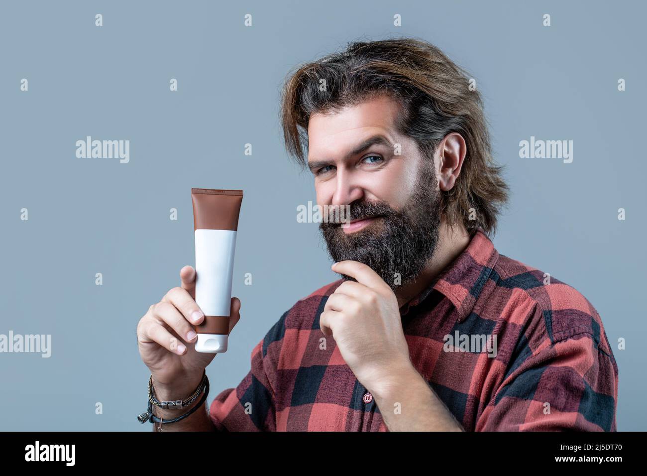 Man holds bottle of shampoo or shower gel. Shampoo conditioner for men ...