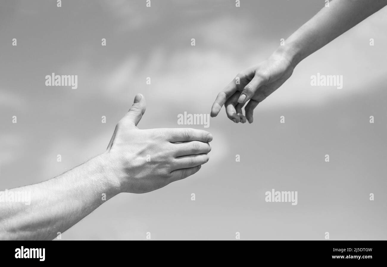 Giving a helping hand. Hands of man and woman on blue sky background ...