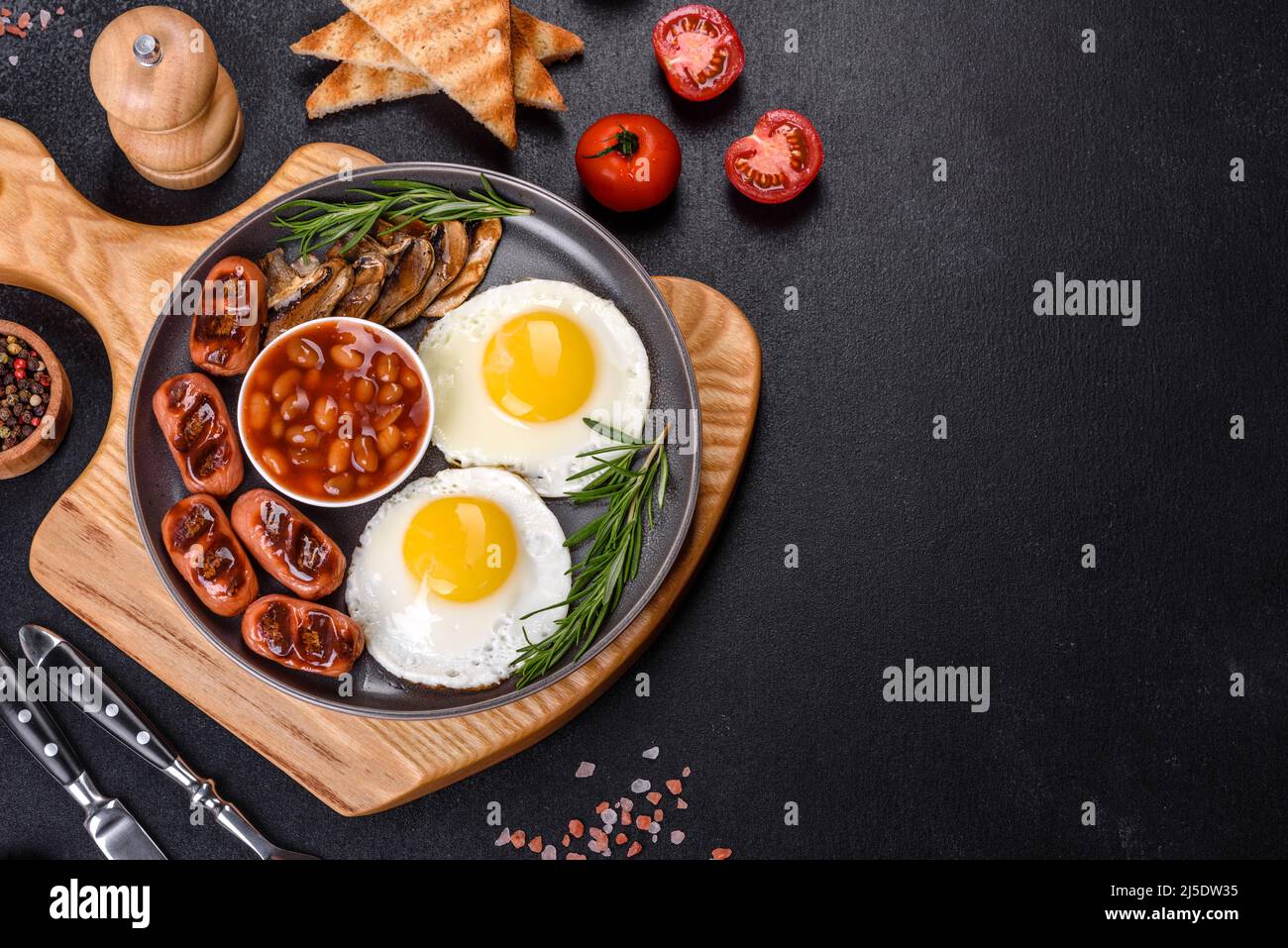 Full english breakfast - bean, fried eggs, roasted sausages, tomatoes ...
