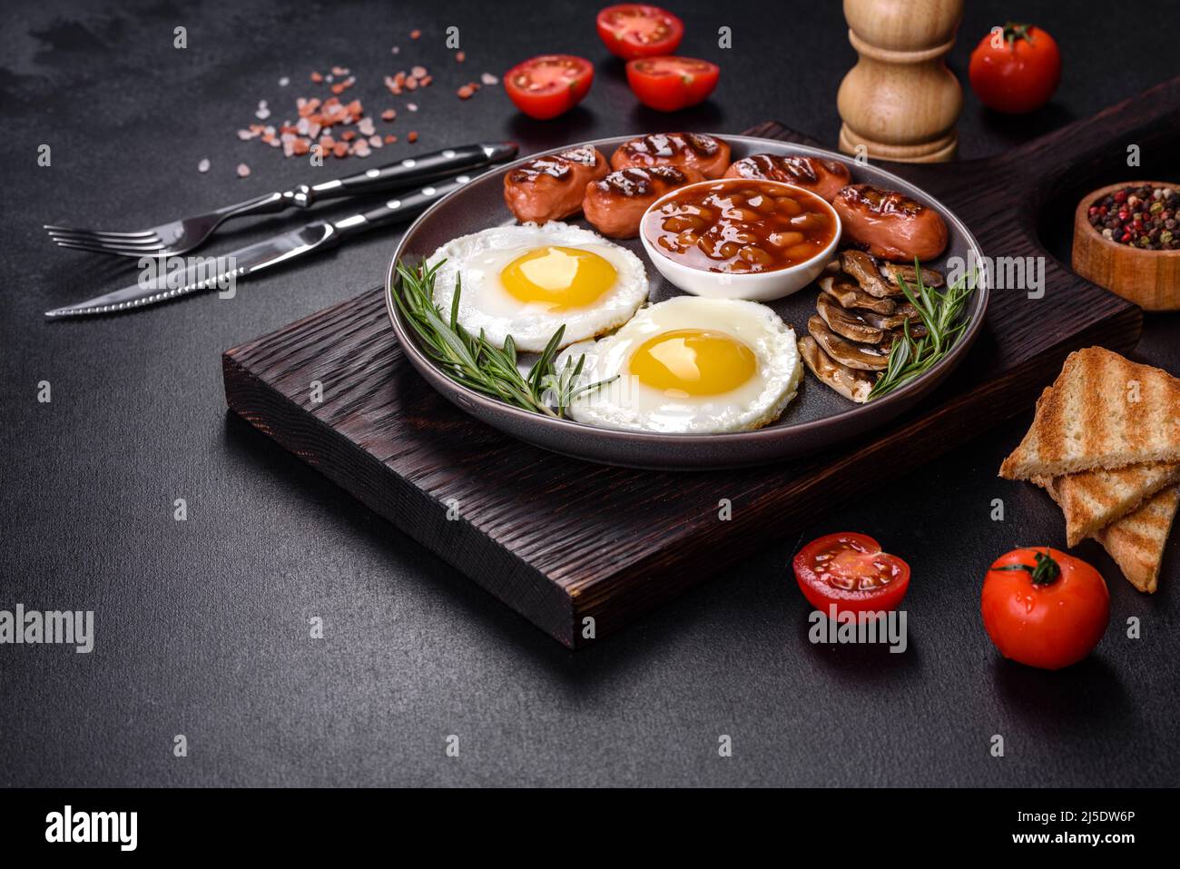 Full english breakfast - bean, fried eggs, roasted sausages, tomatoes ...