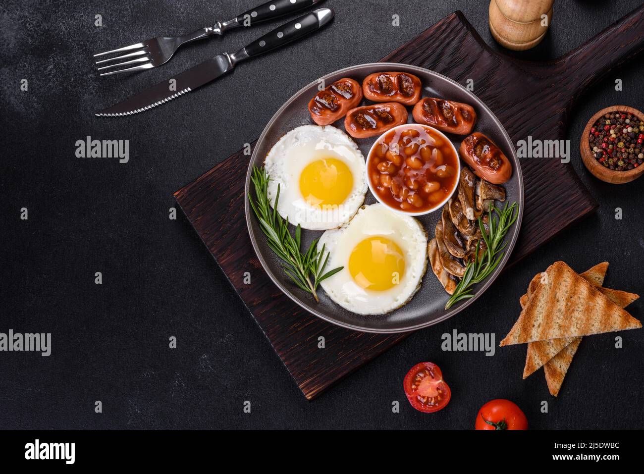 Full english breakfast - bean, fried eggs, roasted sausages, tomatoes ...