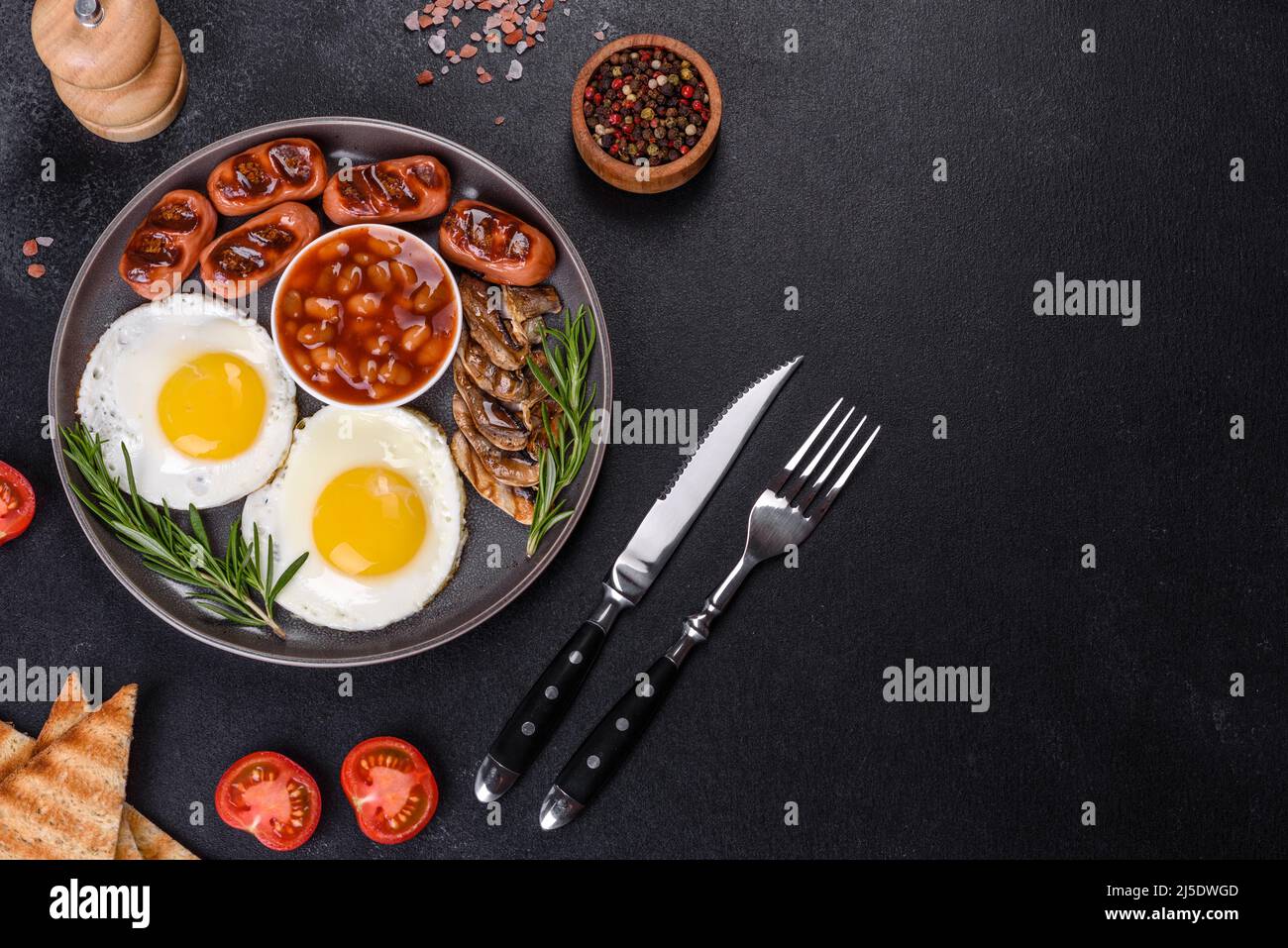 Full english breakfast - bean, fried eggs, roasted sausages, tomatoes ...