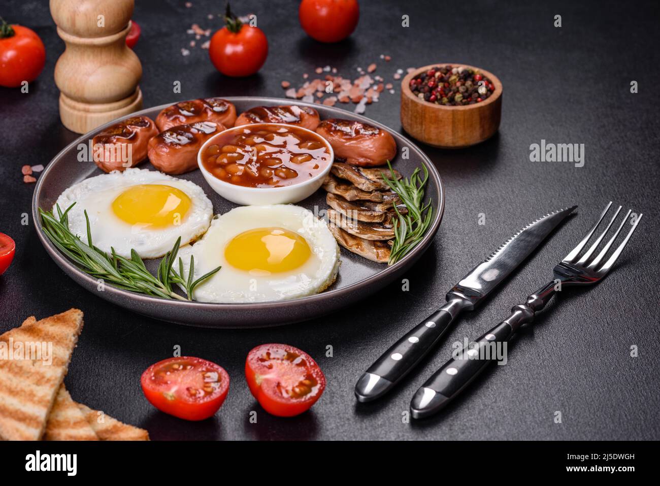 Full english breakfast - bean, fried eggs, roasted sausages, tomatoes ...