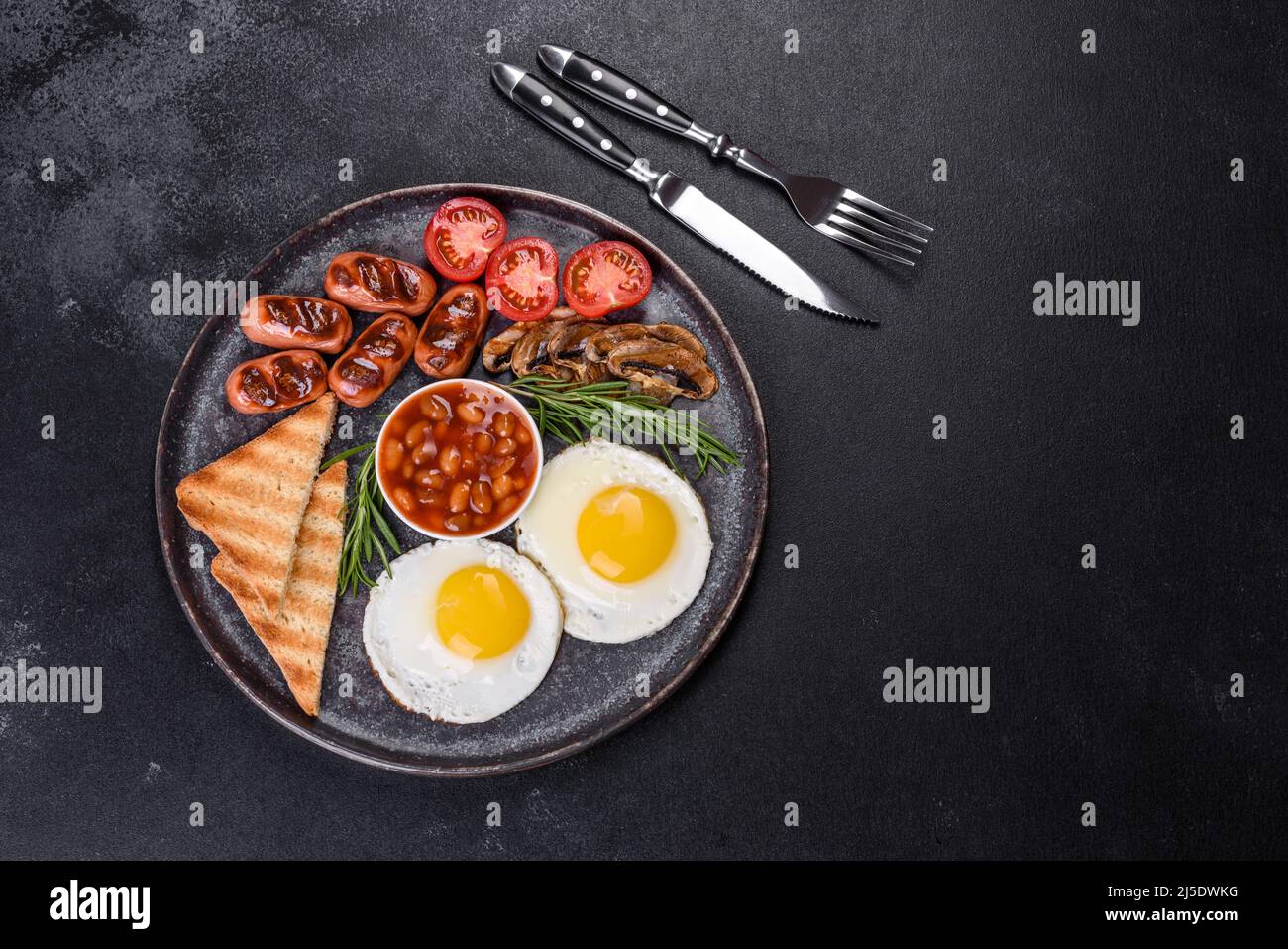 Full english breakfast - bean, fried eggs, roasted sausages, tomatoes ...