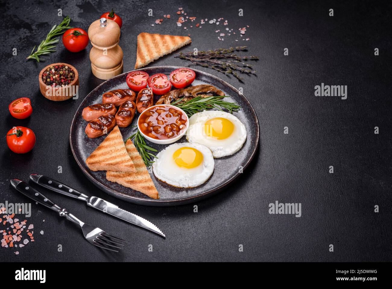 Full english breakfast - bean, fried eggs, roasted sausages, tomatoes ...