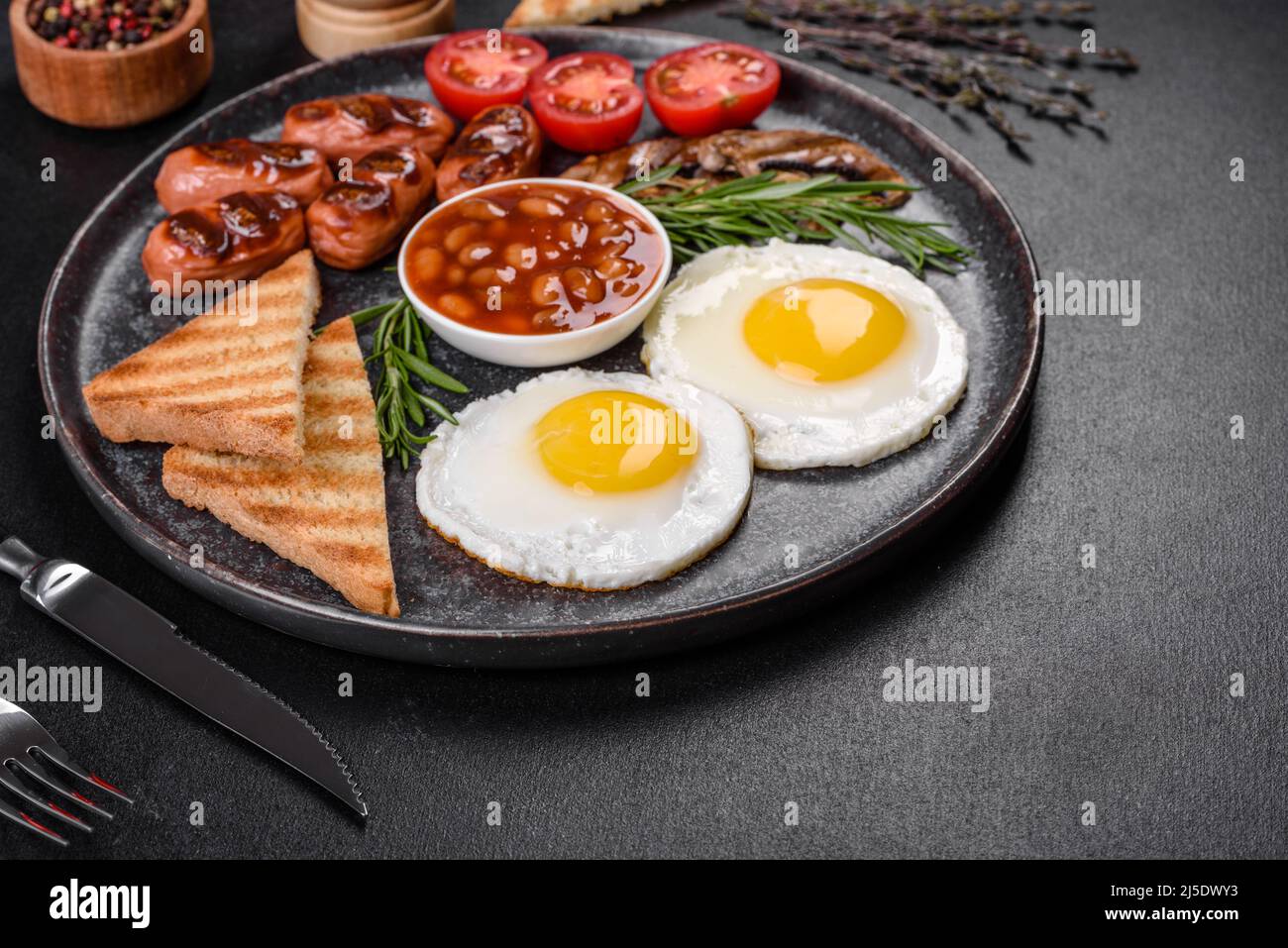 Full english breakfast - bean, fried eggs, roasted sausages, tomatoes ...