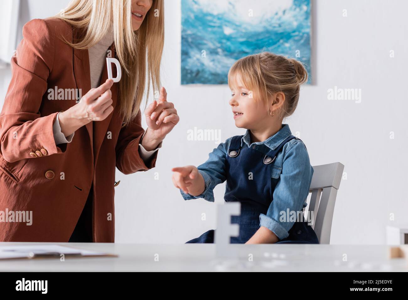 Teacher pointing to letter in classroom hi-res stock photography and ...