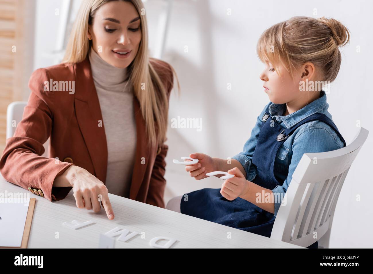 Teacher pointing to letter in classroom hi-res stock photography and ...